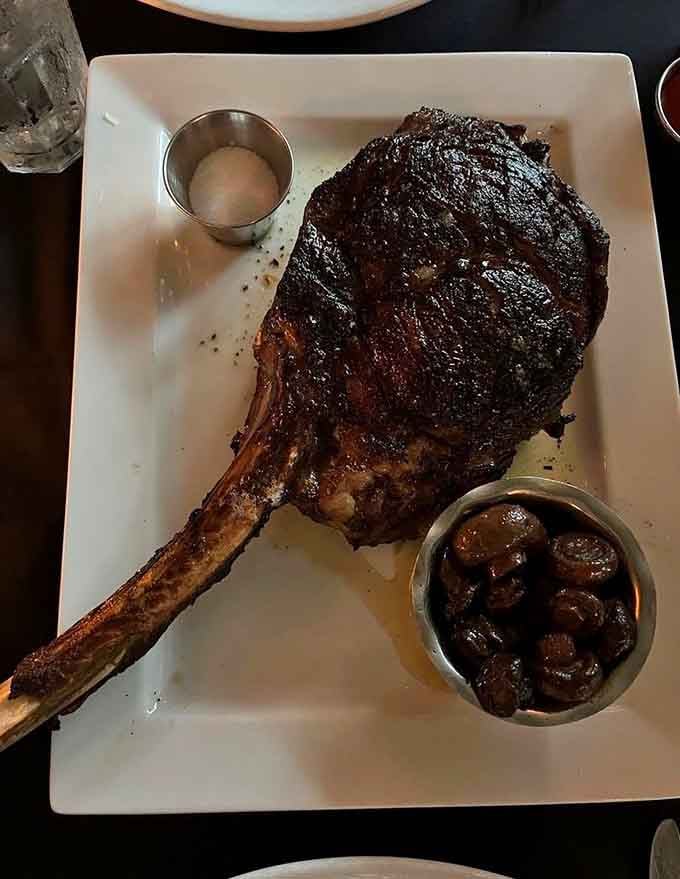 The tomahawk steak arrives like a prehistoric feast, proving bigger really can be better sometimes.