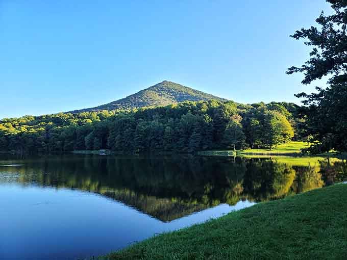 Early morning light transforms the lake into liquid glass, with Sharp Top standing guard like a silent, majestic sentinel.