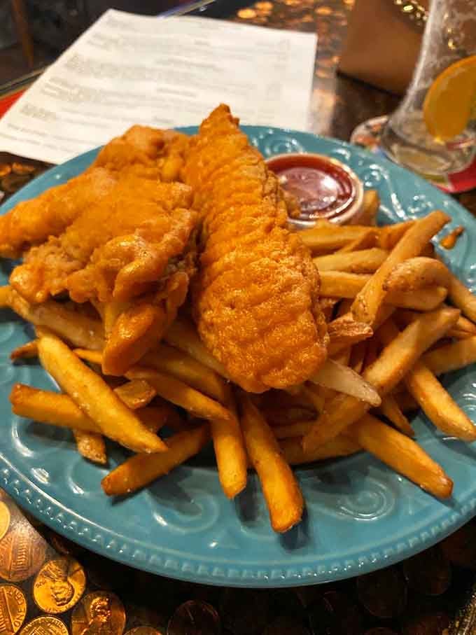 Golden tenders and crispy fries piled high on a blue plate, delivering exactly what your comfort food heart desires.