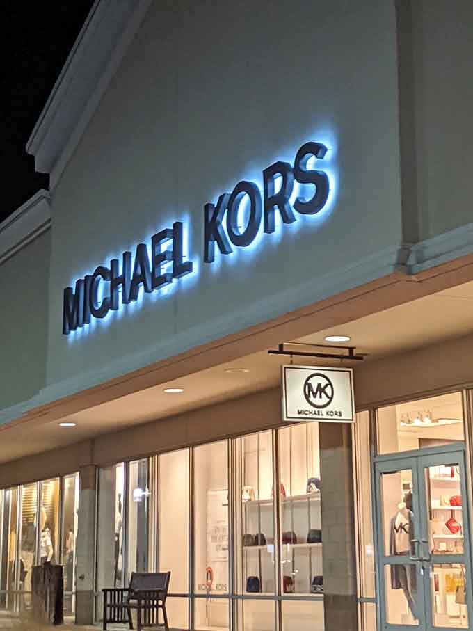 Michael Kors glows invitingly at dusk, where designer dreams become reality without the nightmare of full retail pricing.