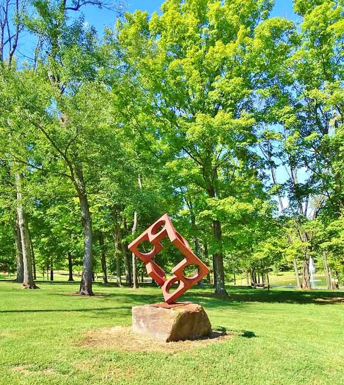 Vibrant orange metal balanced on ancient stone creates a dialogue between modern whimsy and timeless nature.