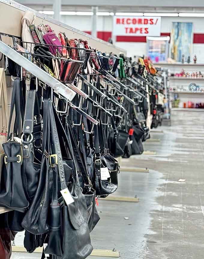 Handbags hanging like a leather and vinyl art installation, each with its own mysterious past.