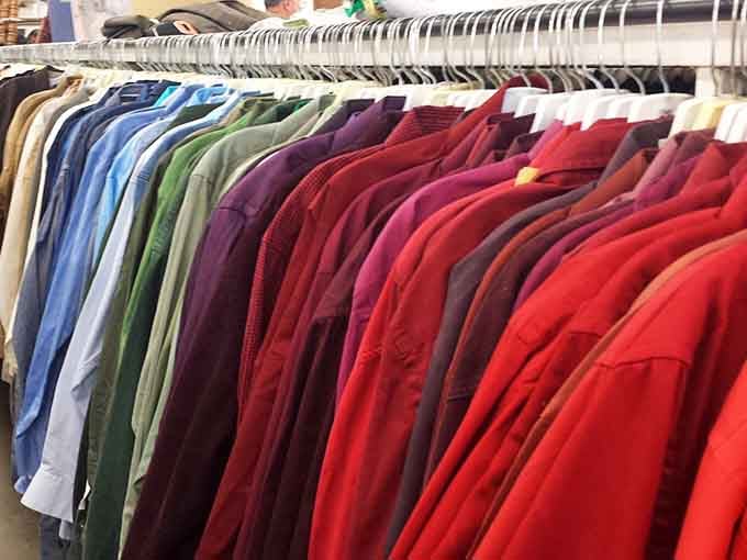 A rainbow of polo shirts organized by color, because even thrift stores deserve some aesthetic appreciation.
