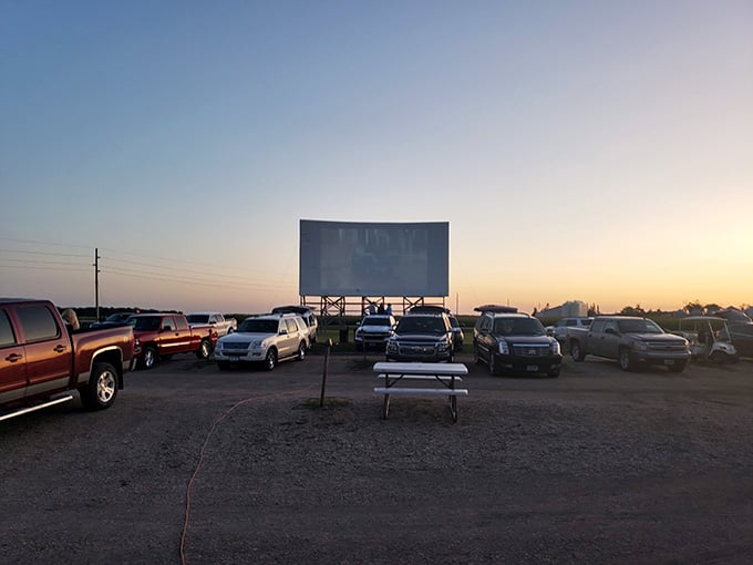Vehicles settling in as the sun dips low, each one a private viewing booth under Minnesota's endless sky.