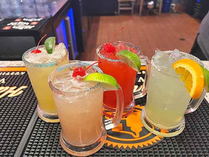 A rainbow of margaritas lined up like liquid vacation, each one promising to transport you somewhere tropical and carefree.