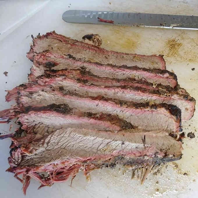 Sliced brisket revealing that coveted pink smoke ring, the hallmark of authentic low-and-slow smoking technique done right.