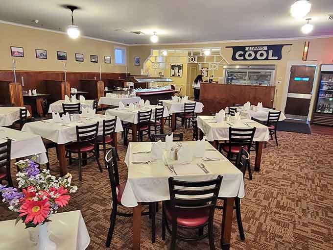 Those white tablecloths and vintage photographs create an atmosphere that feels like Sunday dinner at a really cool aunt's house.