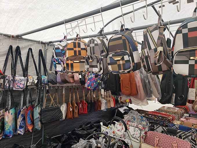 Purses dangle overhead like leather fruit, ripe for picking by shoppers with discerning taste and budgets.