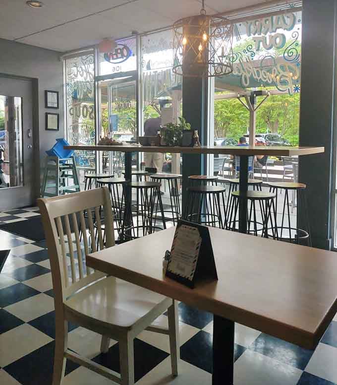 Large windows flood the dining room with natural light while hanging plants add life to this welcoming neighborhood gathering spot.