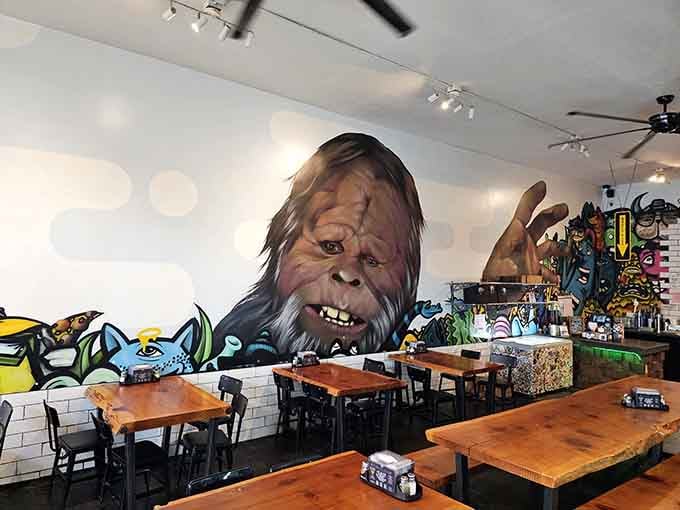 That massive Bigfoot mural watches over diners like a benevolent forest guardian protecting your pizza-eating experience.