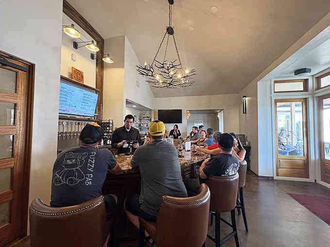 The rustic chandelier overhead and curved bar create an inviting gathering spot where strangers become friends quickly.