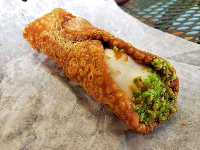 The cannoli shell holds its filling like a delicious secret you're about to discover one glorious bite at a time.