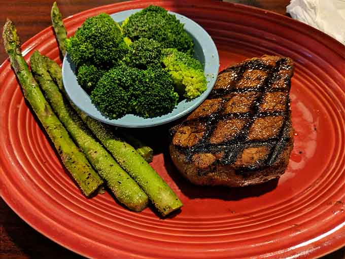 Perfectly grilled filet mignon with vibrant asparagus and broccoli shows this barn knows how to balance a plate beautifully.