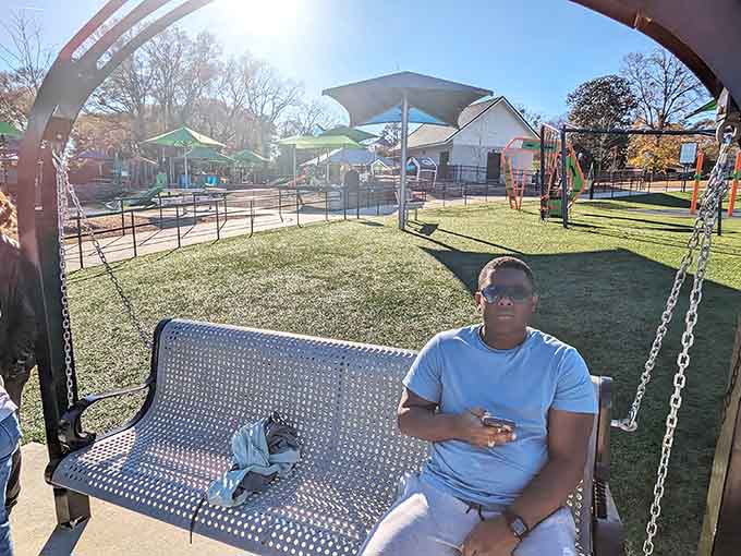 Shaded benches where parents rest while kids play, proving someone understood that adults need breaks too.