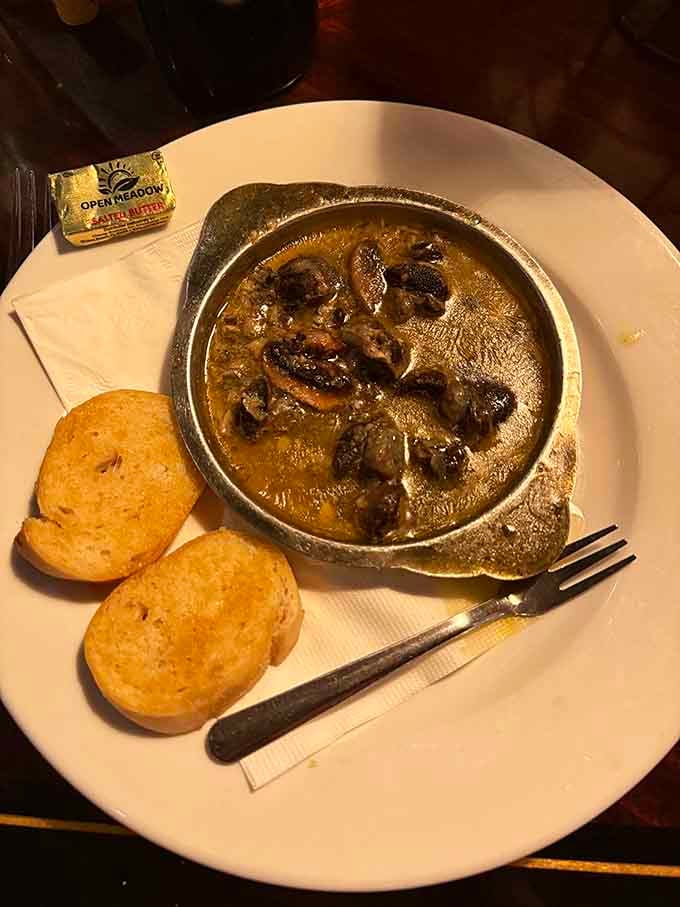 Escargot swimming in garlic butter proves that even snails become superstars with proper French treatment and bread.