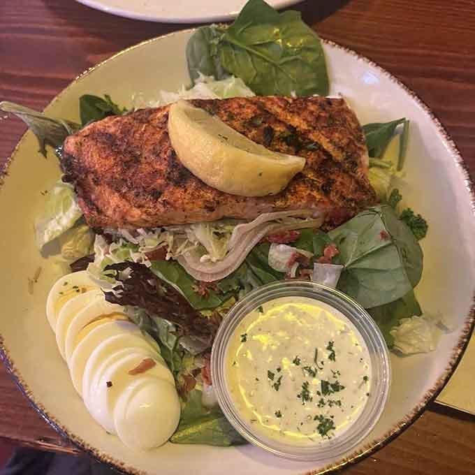 Perfectly seasoned salmon atop fresh greens shows seafood gets the same royal treatment as the beef here.