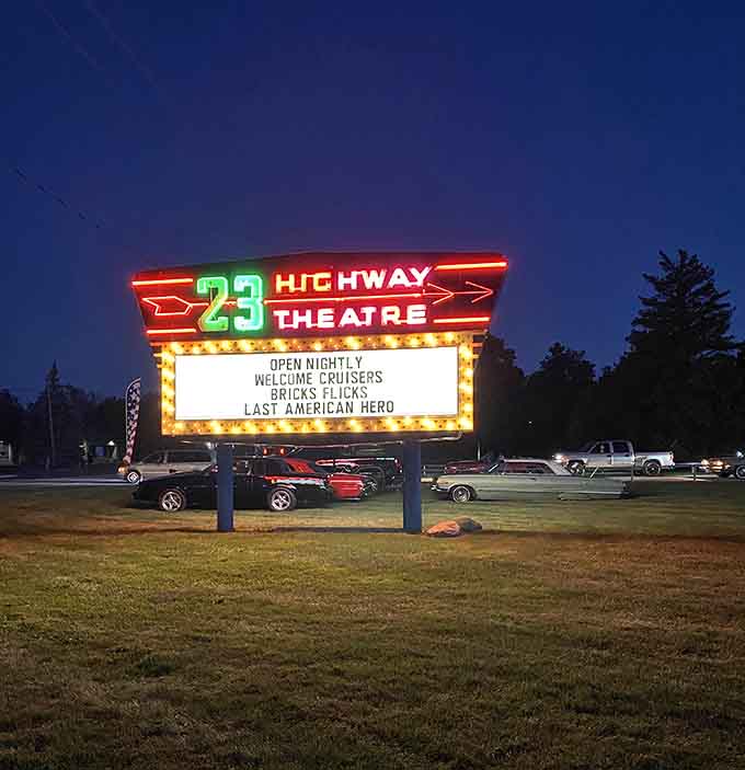 The glowing marquee announces tonight's double feature like a lighthouse guiding ships to entertainment shores safely home.