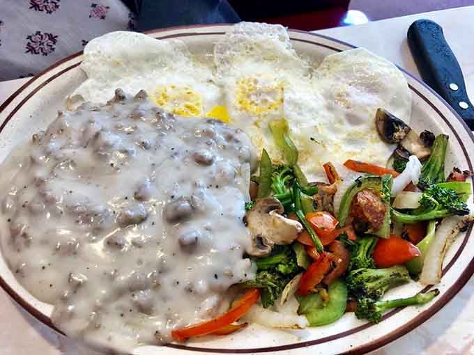 Sausage gravy cascading over eggs and vegetables, a Southern comfort breakfast that'll stick with you through anything.