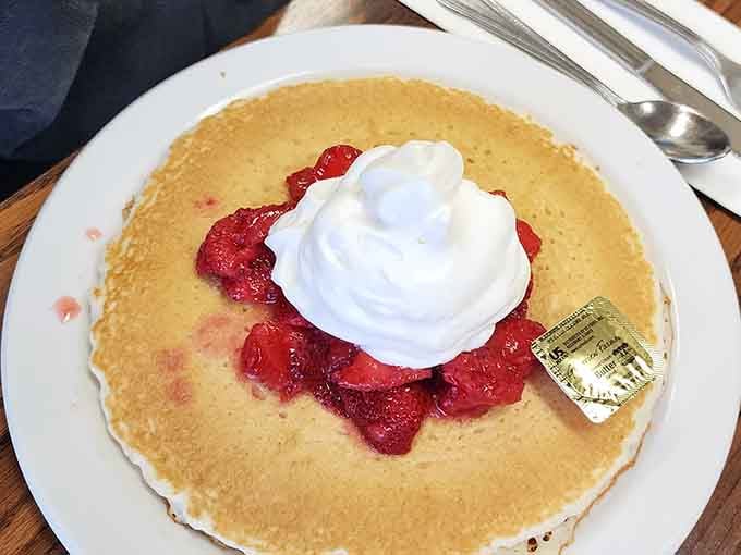 Pancakes topped with strawberries and whipped cream, looking like breakfast won the lottery and shared its winnings.