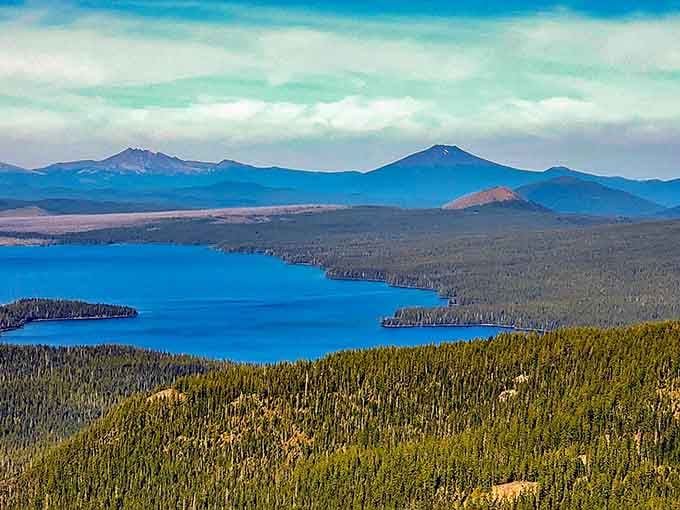 From above, Waldo Lake sprawls like a sapphire dropped in an emerald forest, with mountain peaks standing guard.