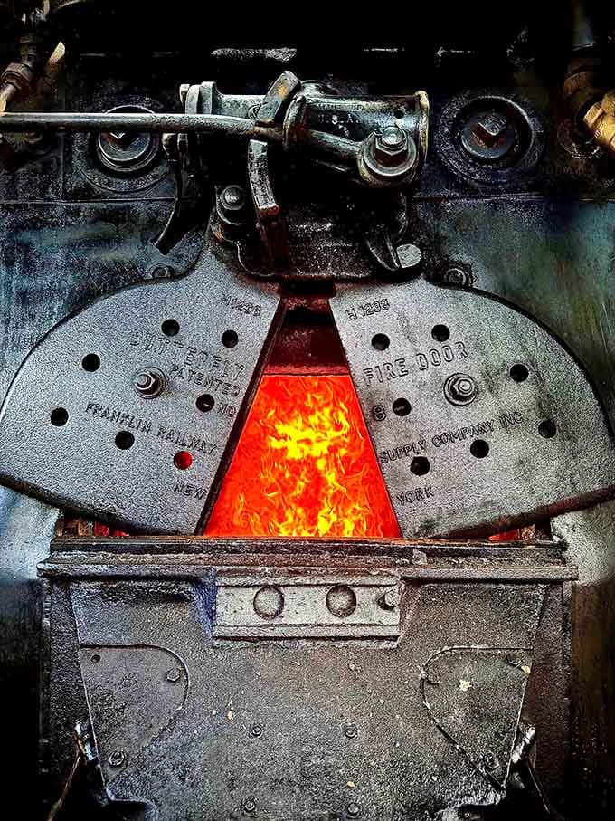 The glowing firebox reveals the raw power that once moved America, still burning bright for your journey today.