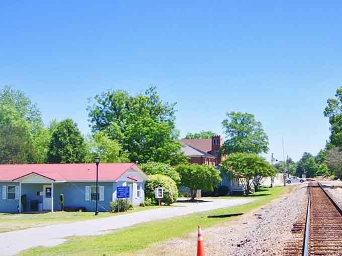 Railroad tracks run alongside these modest buildings where trains once brought commerce and connection to the wider world beyond.