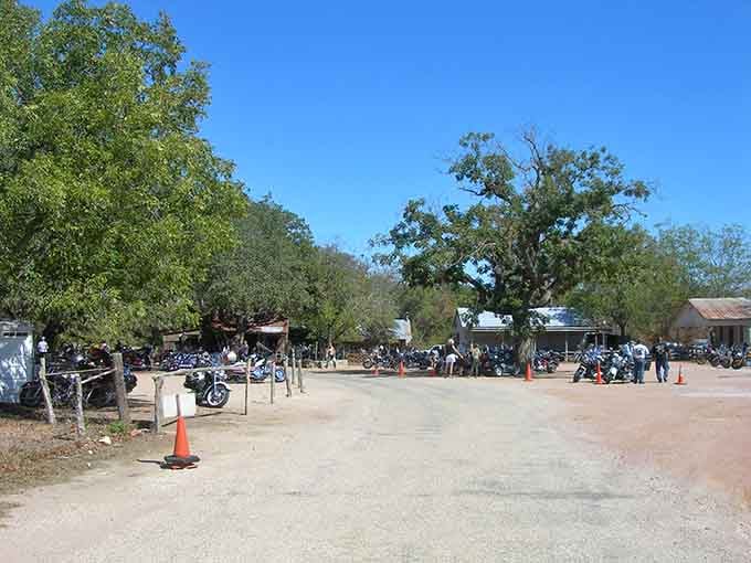 Motorcycles gather under ancient oaks where riders find fellowship, cold drinks, and genuine Texas hospitality awaits.