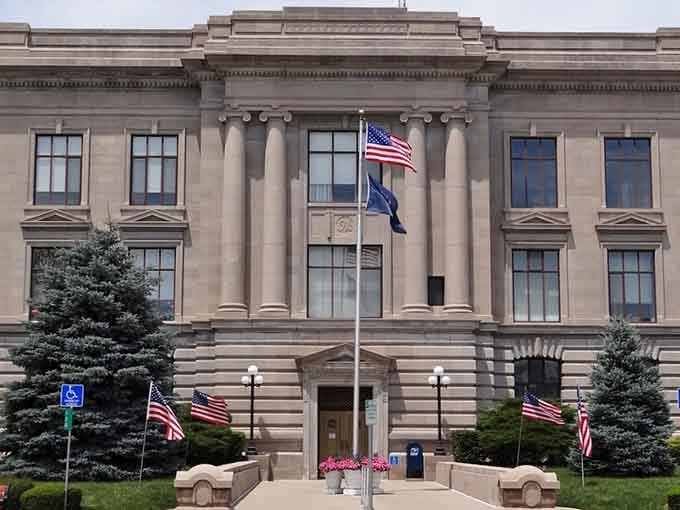 Patriotic flags flutter proudly against limestone columns, showing that civic pride never goes out of style in America's heartland.