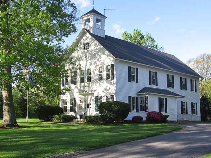 Sunlight dapples this classic white building where generations have gathered, creating memories that last longer than any modern construction.