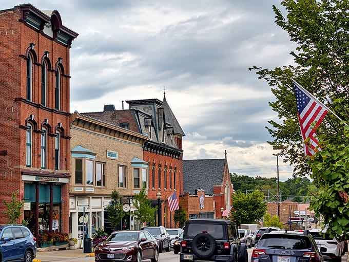 Dramatic skies hover over brick storefronts where American flags wave proudly and parking is still free on most side streets.