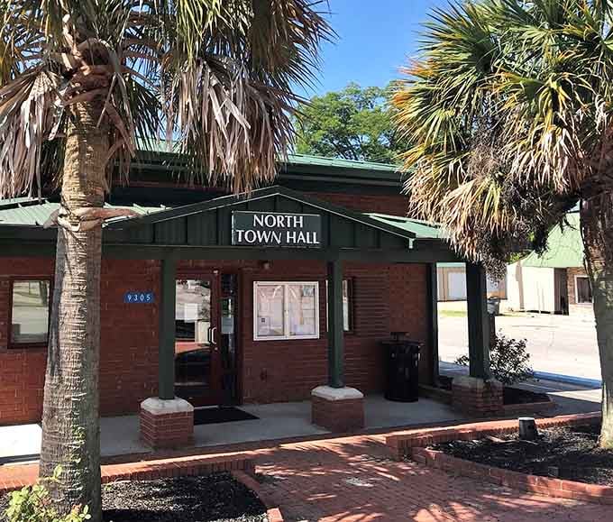 Palm fronds frame the town hall entrance, blending tropical flair with small-town government perfectly.