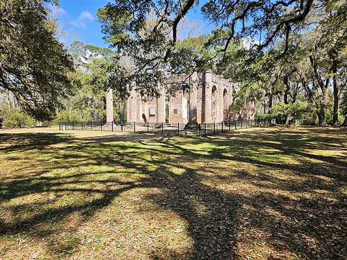 Spanish moss drapes the surrounding oaks while ancient brick walls stand proud, creating haunting beauty from architectural loss.