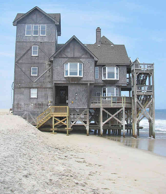 This weathered beach house on stilts has survived storms and starred in movies, earning its iconic coastal status.