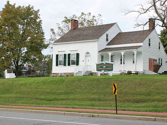 This pristine white colonial sits picture-perfect on manicured lawns, embodying timeless American architecture at its most elegant.