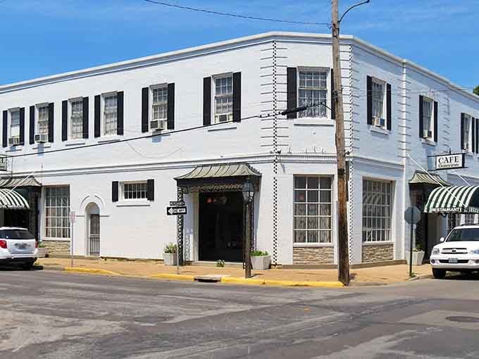 Crisp white columns and black shutters create the kind of corner building that anchors a town's entire character.