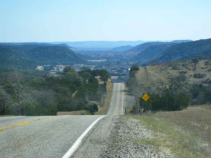Rolling hills descend toward civilization below, reminding us why road trips beat flying every single time.