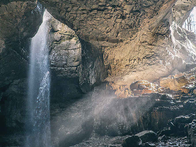 The stunning waterfall inside Stephens Gap creates an otherworldly atmosphere as sunlight streams through the opening above the cave floor below.