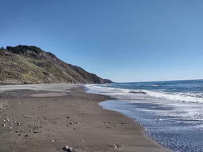 That black sand beach stretching into forever is your reward for surviving the drive in.