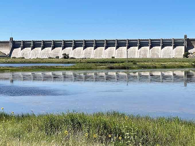 That concrete dam rising from the plains proves humans occasionally build something worth photographing instead of complaining about.