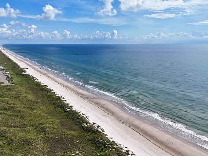This aerial view shows just how beautifully undeveloped Malaquite Beach remains, with natural dunes protecting the pristine shoreline beyond.