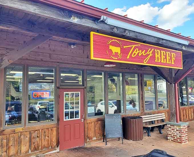 That rustic wooden storefront and bright red sign promise serious burger business, like finding a steakhouse disguised as a cabin.