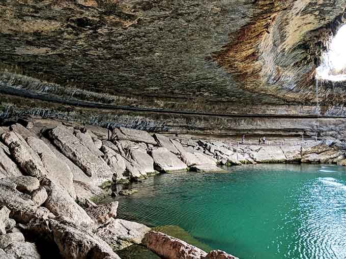 That emerald water beneath ancient limestone layers looks like nature's own private grotto designed just for you.