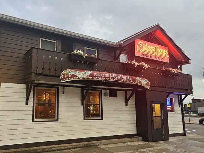 That chalet-style balcony and glowing neon sign say everything: warmth, cold drinks, and something delicious waiting inside.