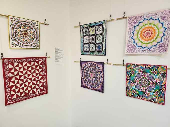 These quilts hang like masterpieces in a gallery, which is exactly what they are, just softer and warmer.