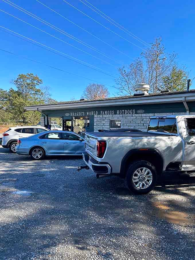 That gravel parking lot means business, the kind where pickup trucks and sedans unite over affordable hot dogs.