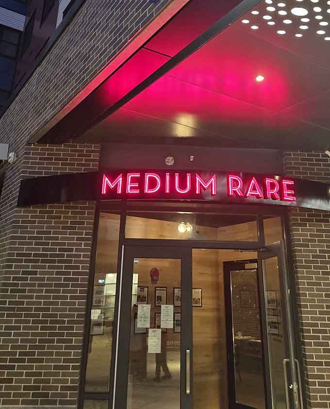 That glowing red sign beckons like a beacon for carnivores, promising steak salvation in the heart of Watertown.