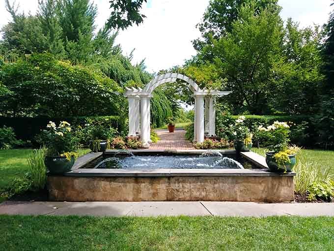 The elegant white pergola and fountain create a peaceful focal point that's perfect for photos and quiet contemplation at the arboretum.