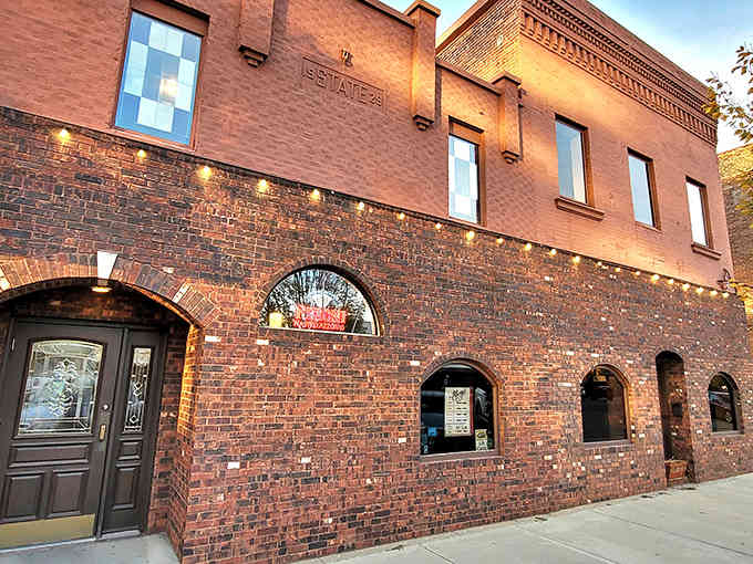 That brick exterior has witnessed nearly nine decades of pizza history, and those arched windows have seen it all.