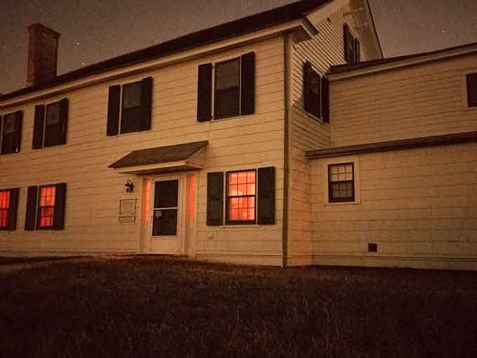 Those glowing windows at dusk aren't just atmospheric lighting, they're basically a neon sign saying "ghosts welcome."