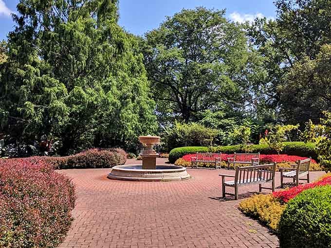 The formal terrace area features a beautiful fountain surrounded by benches, perfect for relaxing while taking in the colorful seasonal blooms all around.